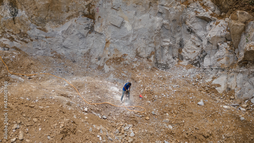 Construction worker electric drill Drilling mountain ground in ...