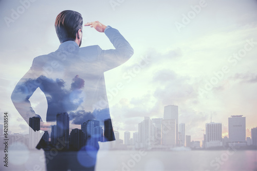 Back view of young european businessman looking into the distance on ...