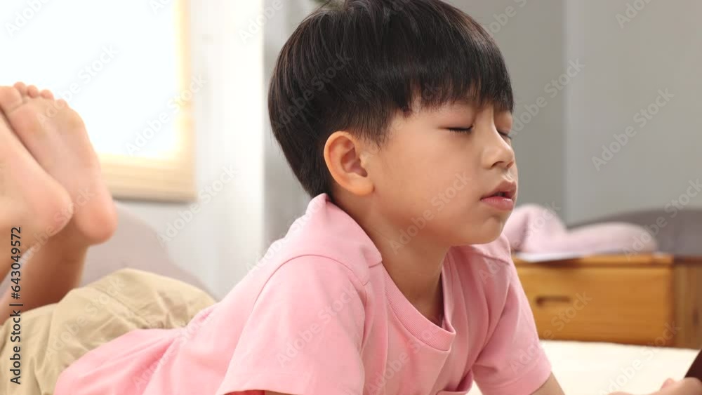 Asian little child boy feeling sleepy and yawn while reading favorite ...
