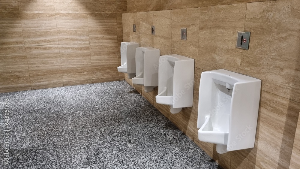 White urinals in men's bathroom. Men's restroom with white porcelain ...