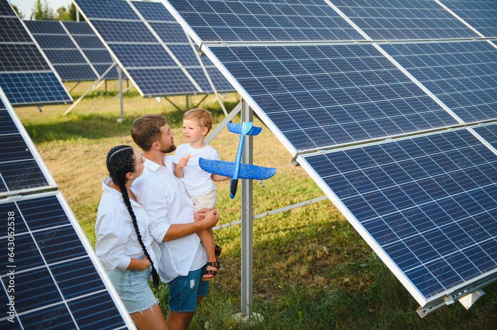 Young family with a small child in her arms on a background of solar ...