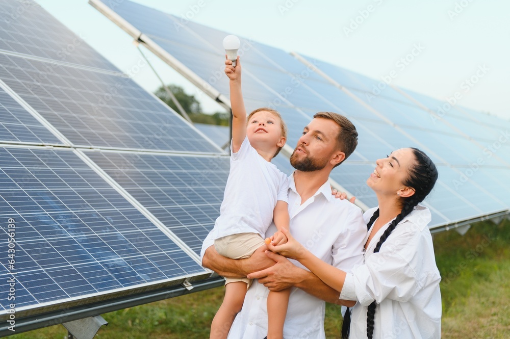 Solar energy concept. A young, happy family is standing near solar ...
