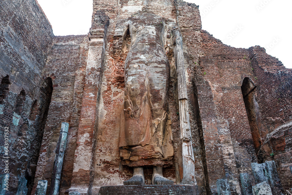 A giant masoned standing Buddha statue without head in a temple in the ...