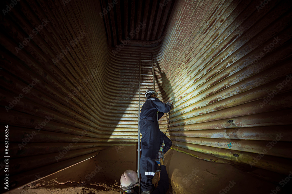 Male worker inspecting up climbing ladder measured the coil pipe ...