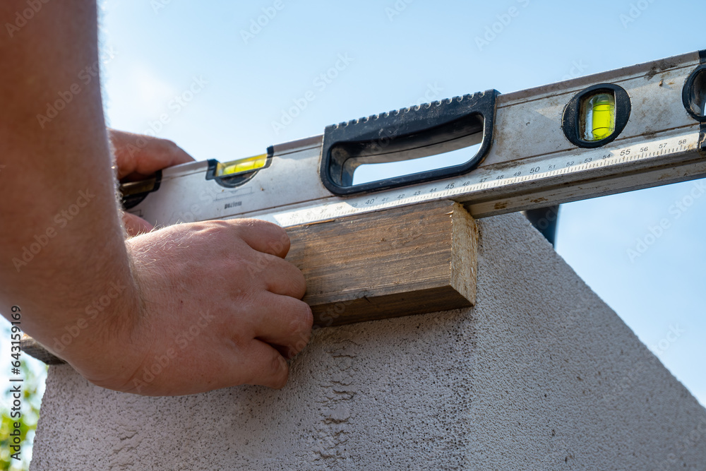 The builder measures the horizontal level of the brickwork. Building ...