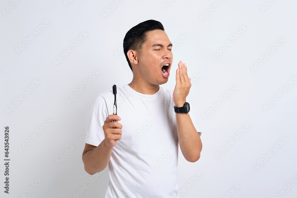 Portrait of young Asian man in white t-shirt checking his breath ...