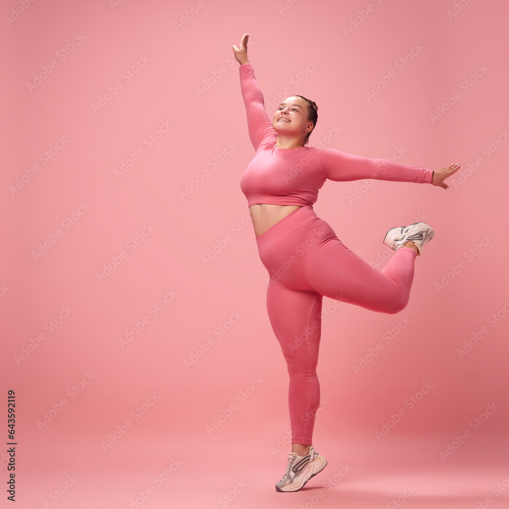 Full length happy young overweight plus size active woman in pink top ...