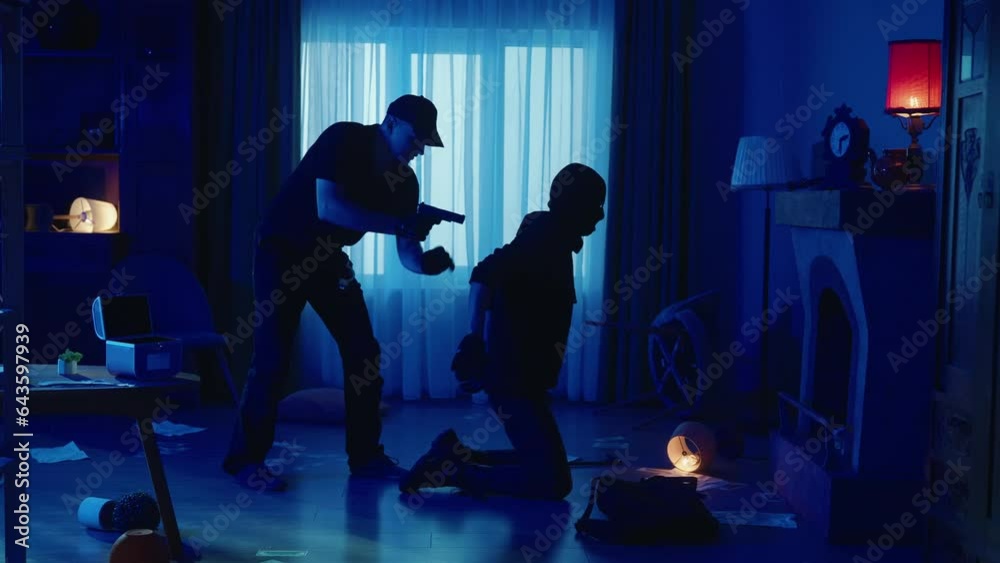 The arrest of a robber in a dark apartment lit with blue red light ...