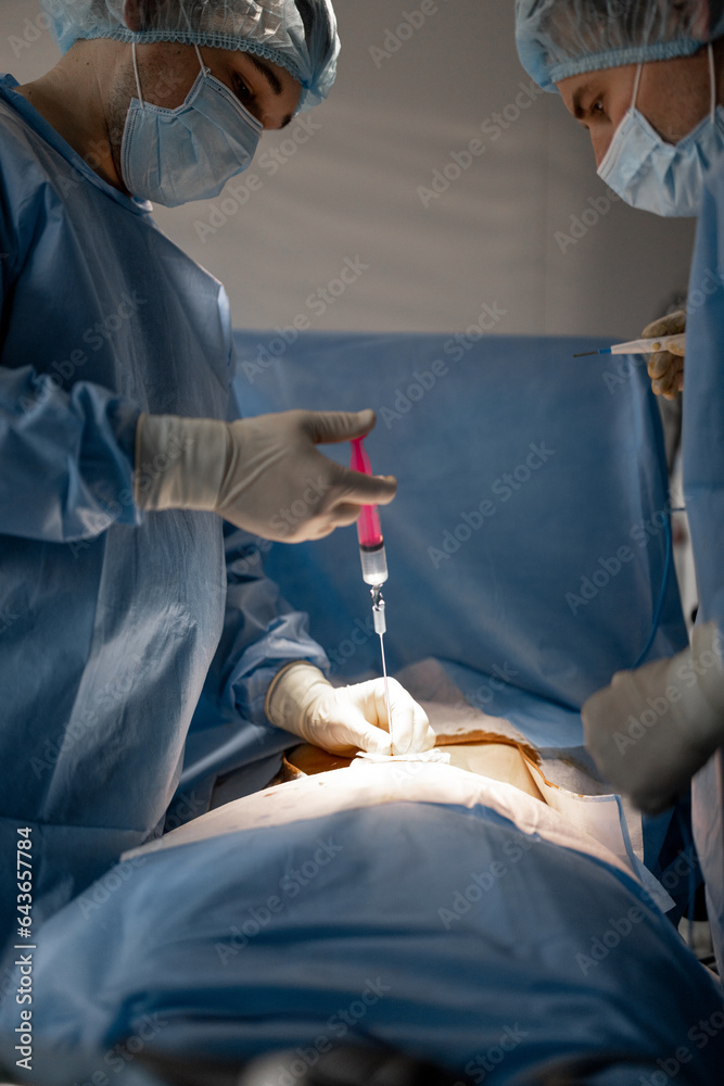Surgeon makes an injection during an operation. Concept of real ...