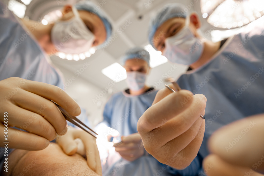 Poster Surgeons performing surgical operation, wide view from below ...