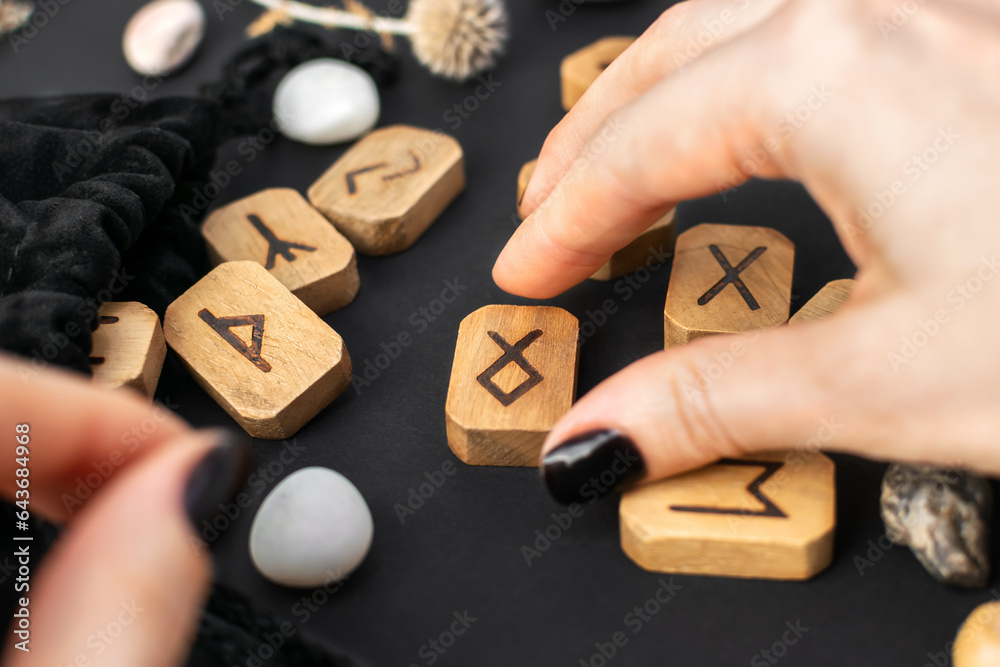 Wooden rune Odal (Othala) is the rune of inheritance in hand on black ...