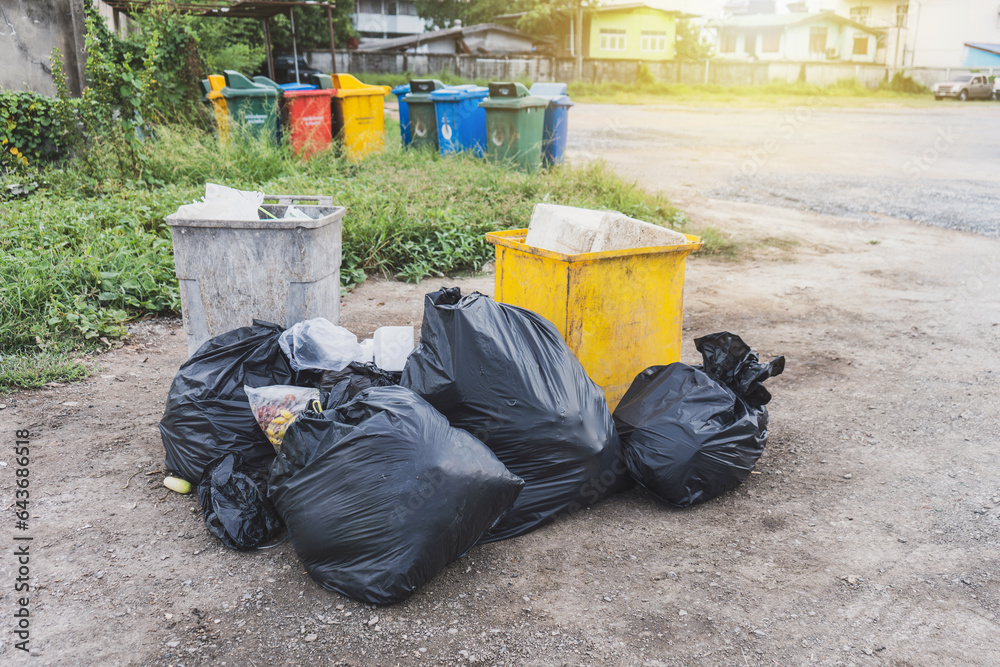 Trash bin full of garbage with a pile of black garbage bag on the ...