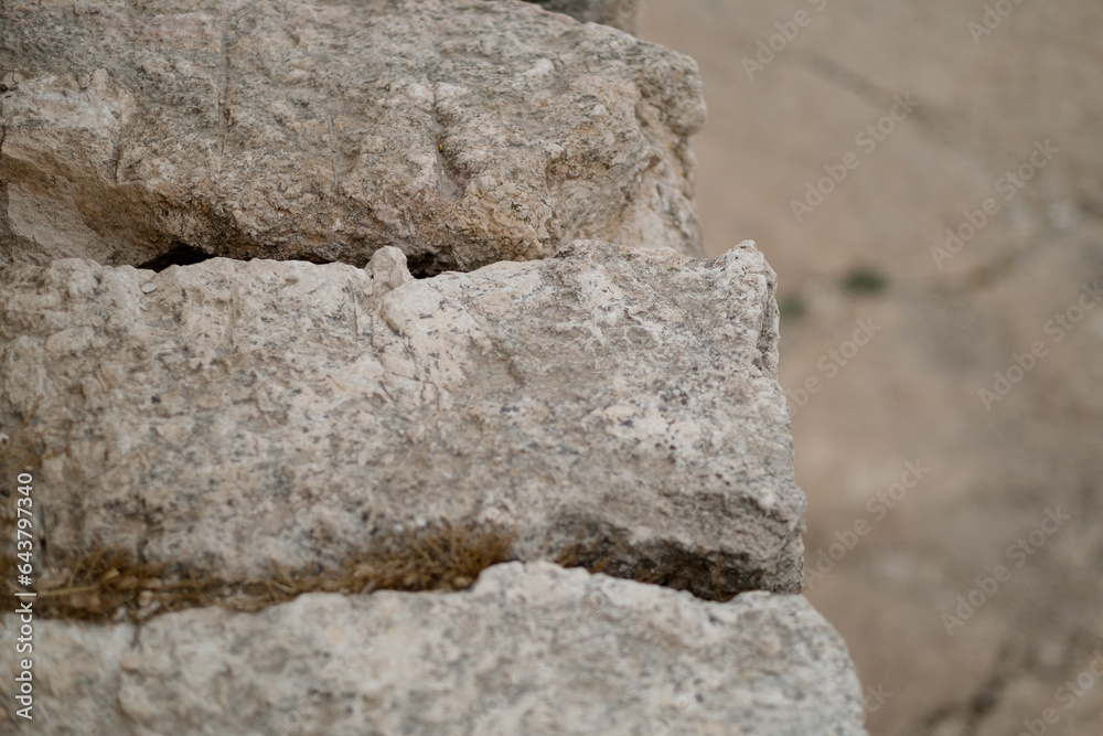 Massive stone blocks are lined up at the base of the wall of an ancient ...