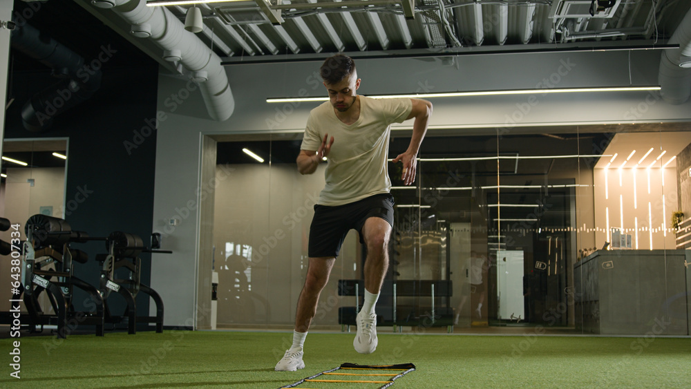 Fotka „Professional footballer man with muscular legs run in gym use ...