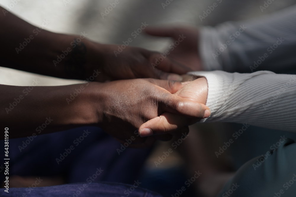 Two people face each other and hold hands. Their hands are clasped ...