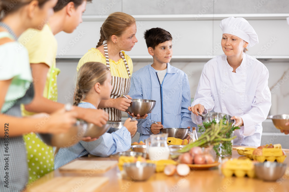 Amiable woman, qualified chef wearing white cook jacket and toque ...