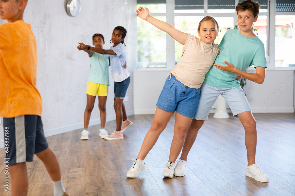 Positive tweenagers, boy and girl dancing together slow ballroom dances ...