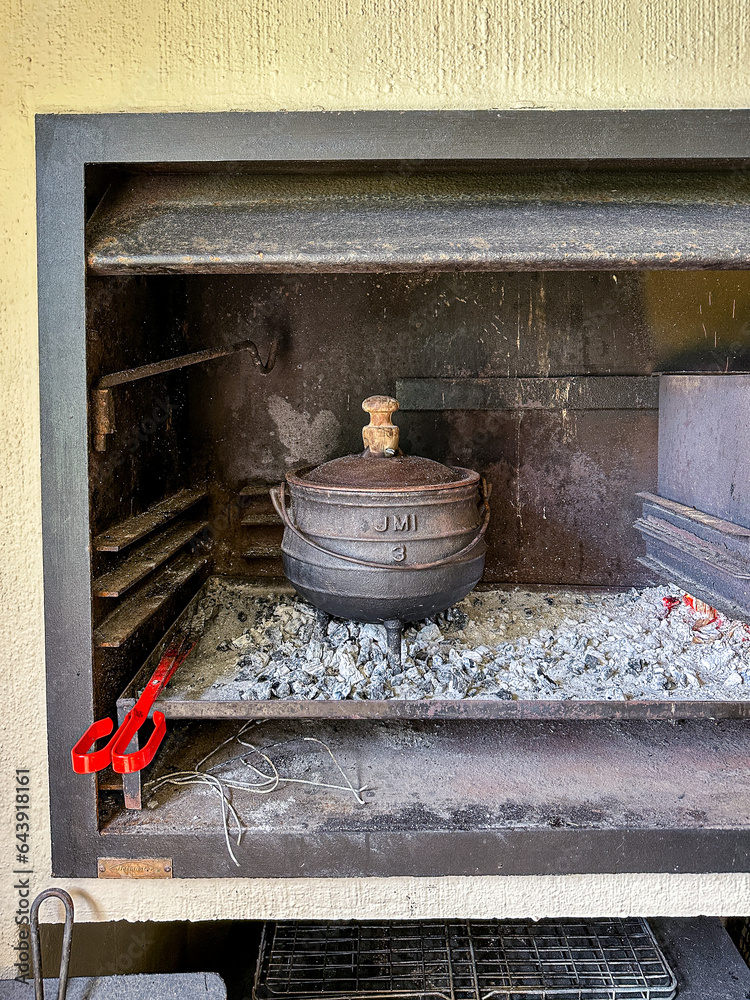 A round, cast iron, three-legged cauldron, called the potjie, used to ...
