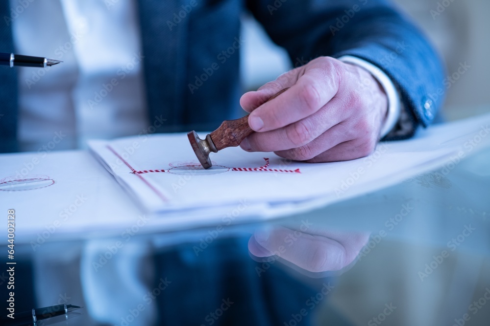 Notary or judge affixes a seal on an important official document in his ...