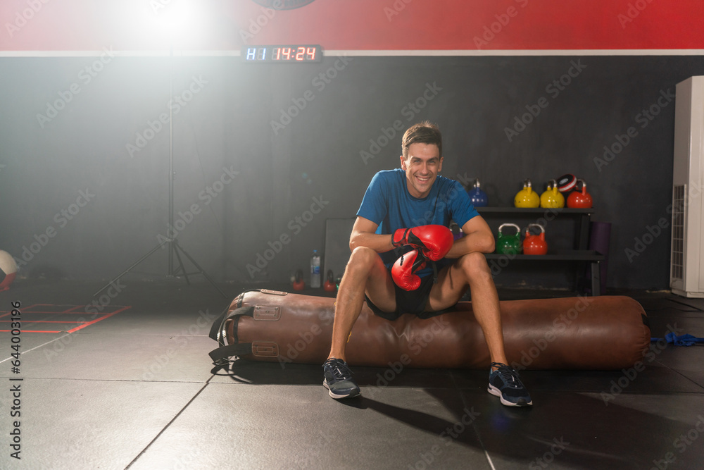 Tall white man in a blue tee shirt takes a well-deserved rest, sitting ...