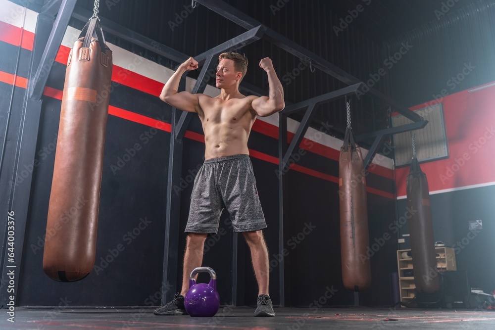 Handsome and muscular white man lifts heavy dumbbells, showcasing his ...