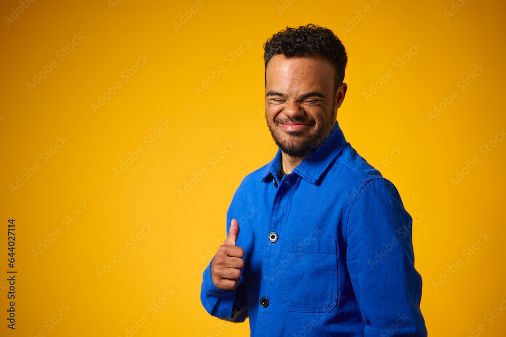 Studio Portrait Of Man With Down Syndrome Standing Against Yellow ...