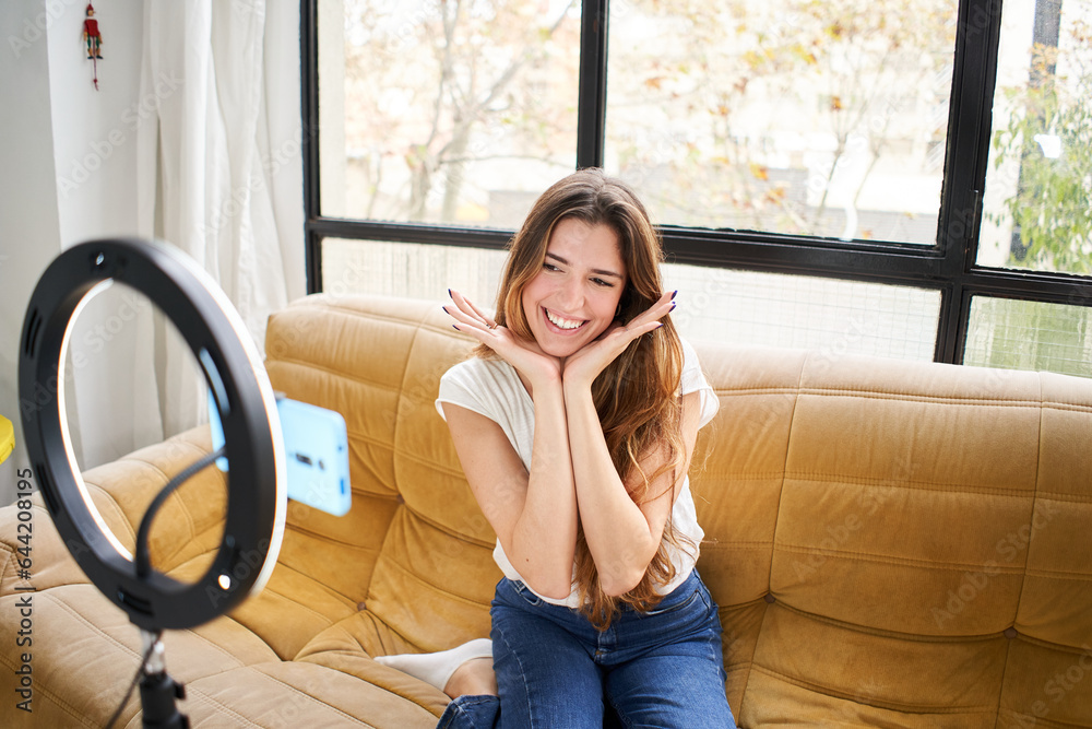 Young beautiful influencer posing smiling for her followers indoors ...