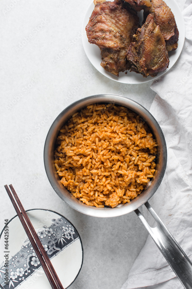 Jollof rice and fried chicken in a silver saucepan, homemade nigerian ...