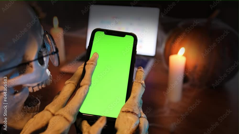 Death character in halloween costume uses phone, scrolling feed ...