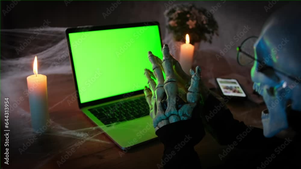 Death skeleton rubbing bone hands at laptop with chromakey and type ...