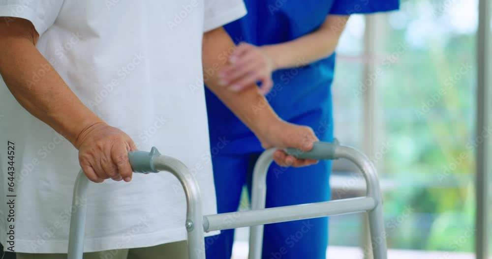 Female patient holding a walker and trying to practice walking in ...