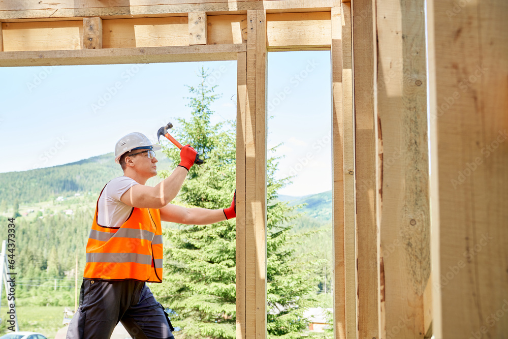 Side view of professional worker, builder standing, holding hammer and ...