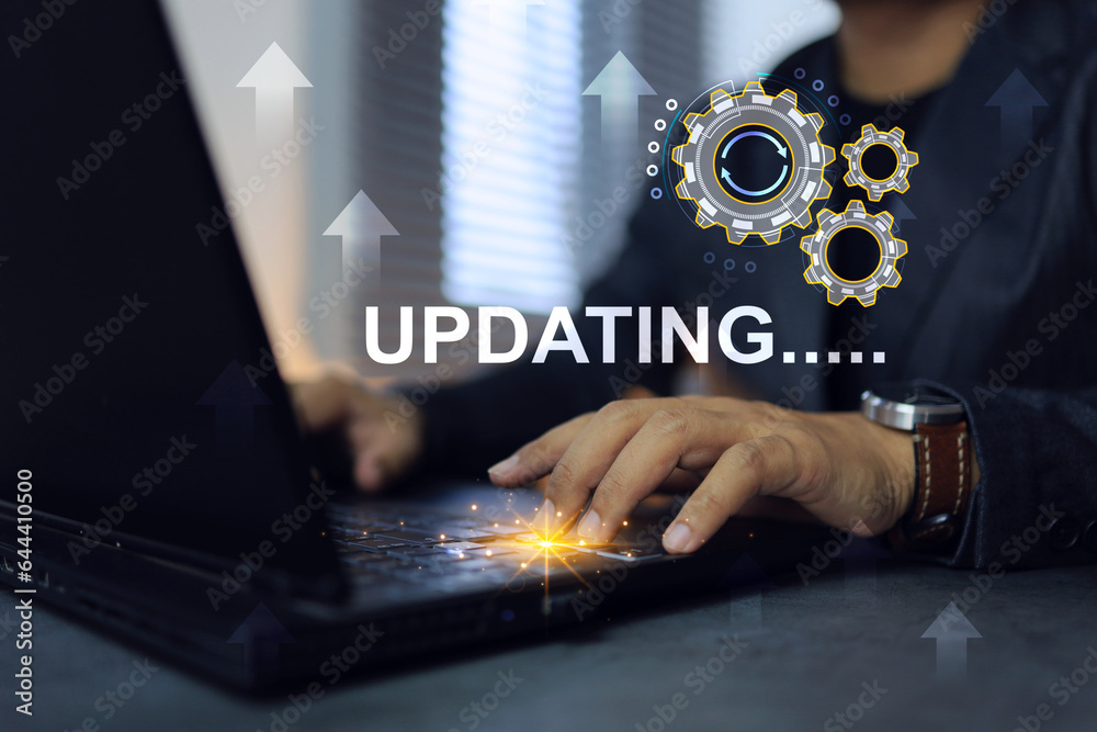 Businessman updating information via laptop or software update for ...