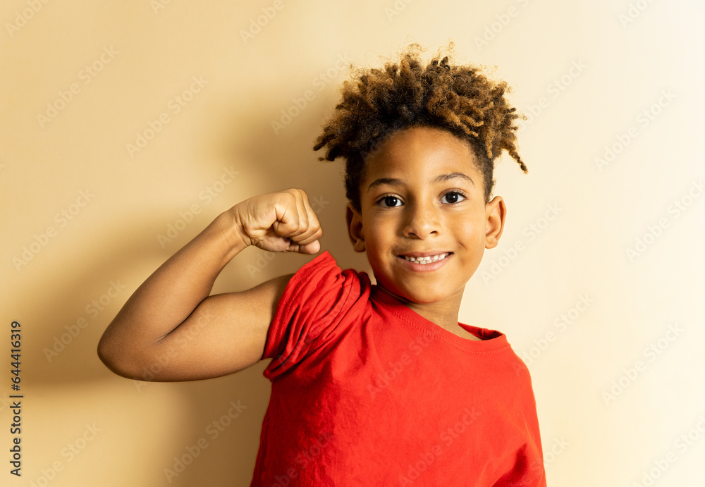An African boy between 5 and 6 years old with afro hair is happily ...