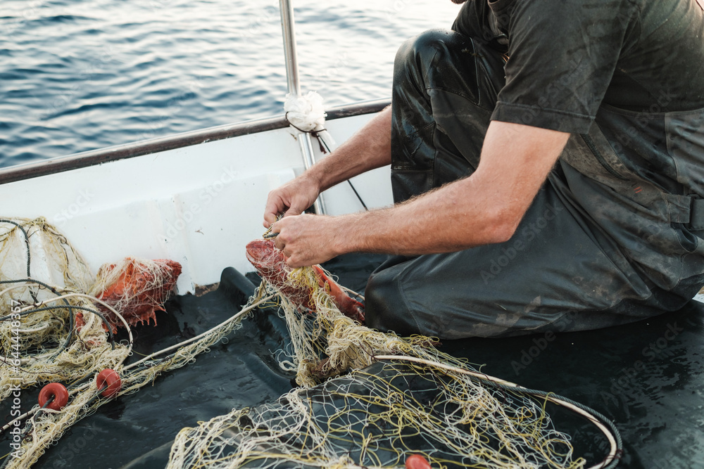 Anonymous man hand untangling fishing net threads to catch fish in ...