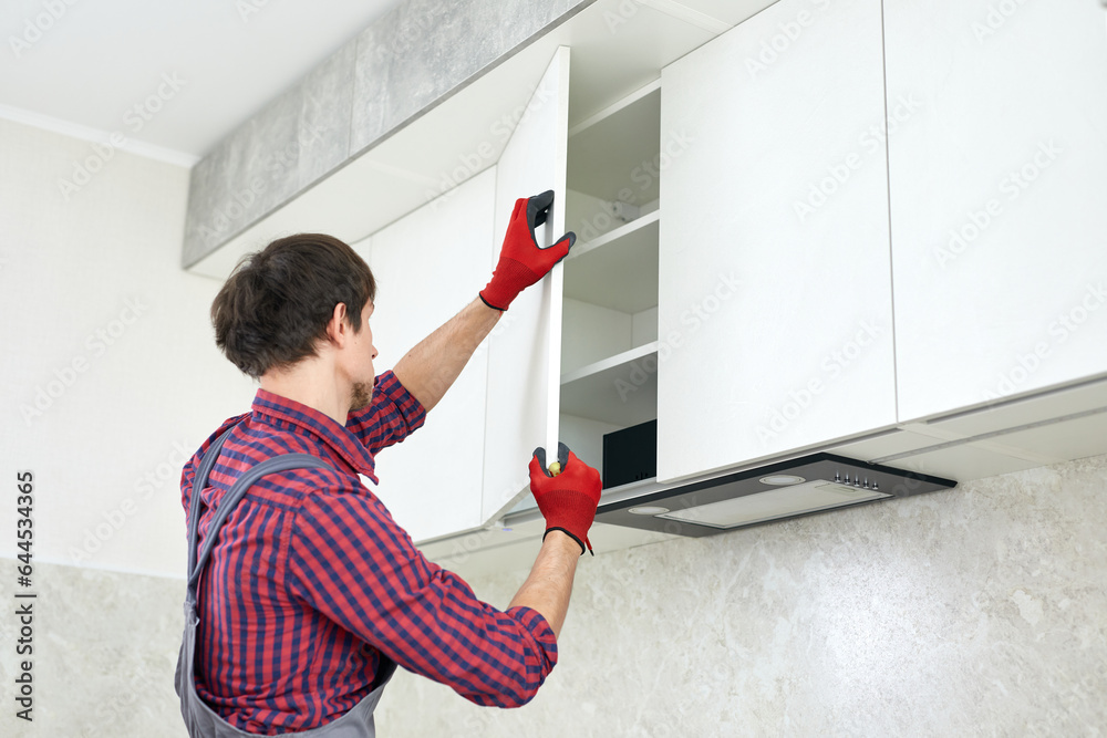 Furniture Worker Assembling Door At Kitchen Closets And Cabinets