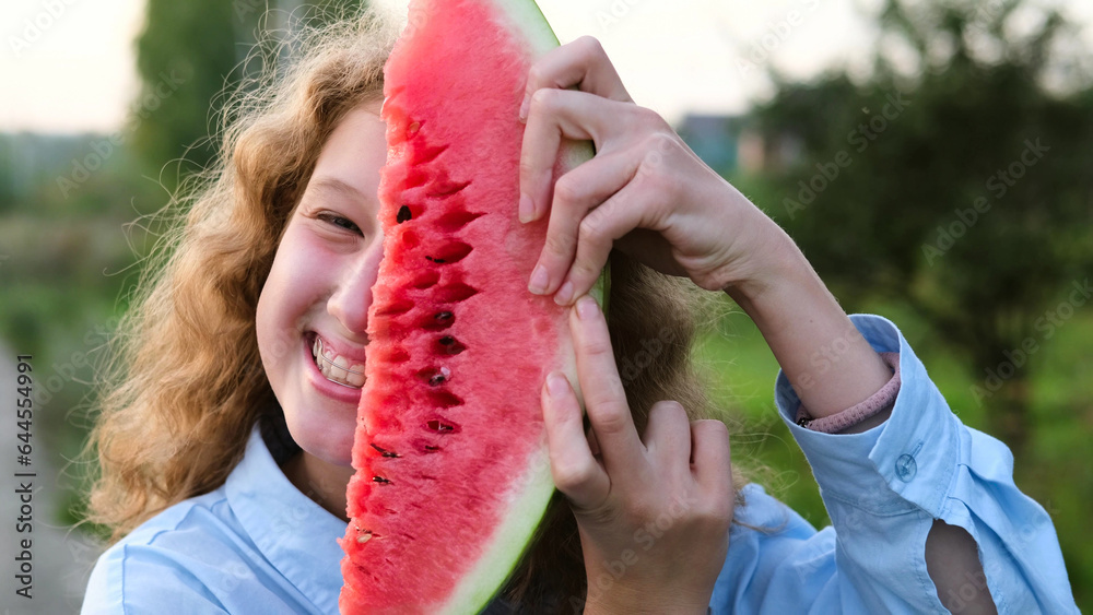The child eats watermelon in the garden. Teenage girl with retainers on ...