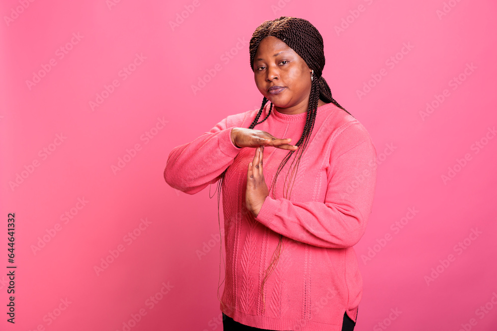 Foto de Displeased angry woman doing timeout and break gesture while ...
