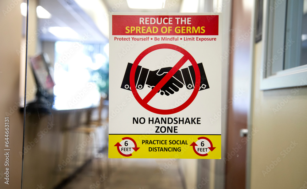 Sign stating No Handshake Zone in an office. The sign refers to ...