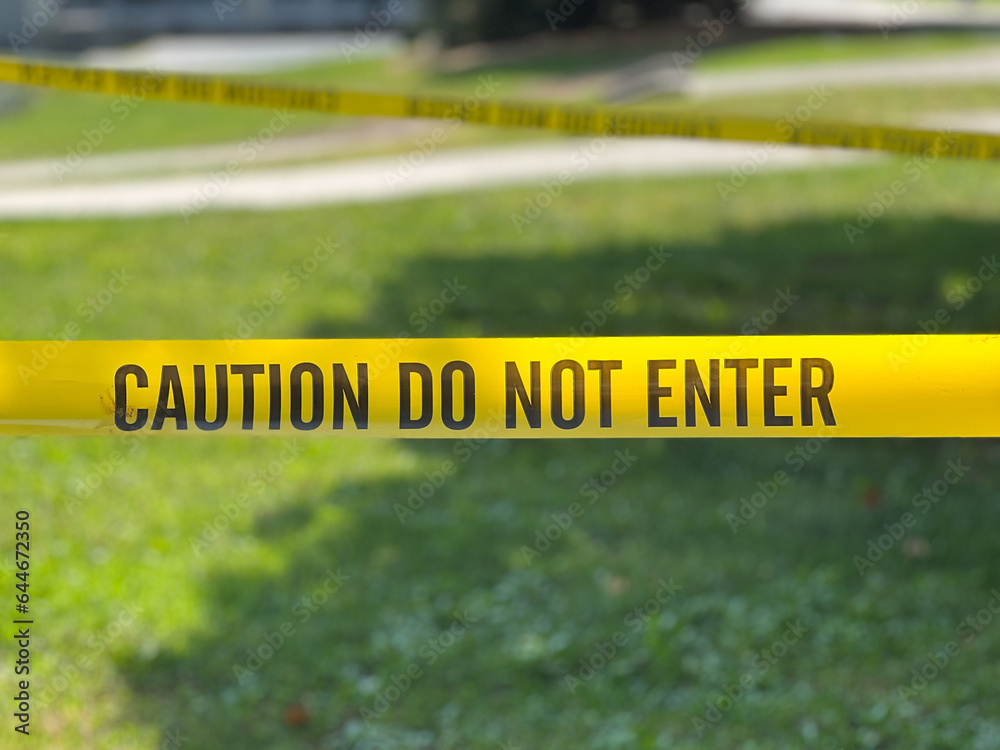 Caution Do Not Enter yellow tape with black lettering warning access to ...