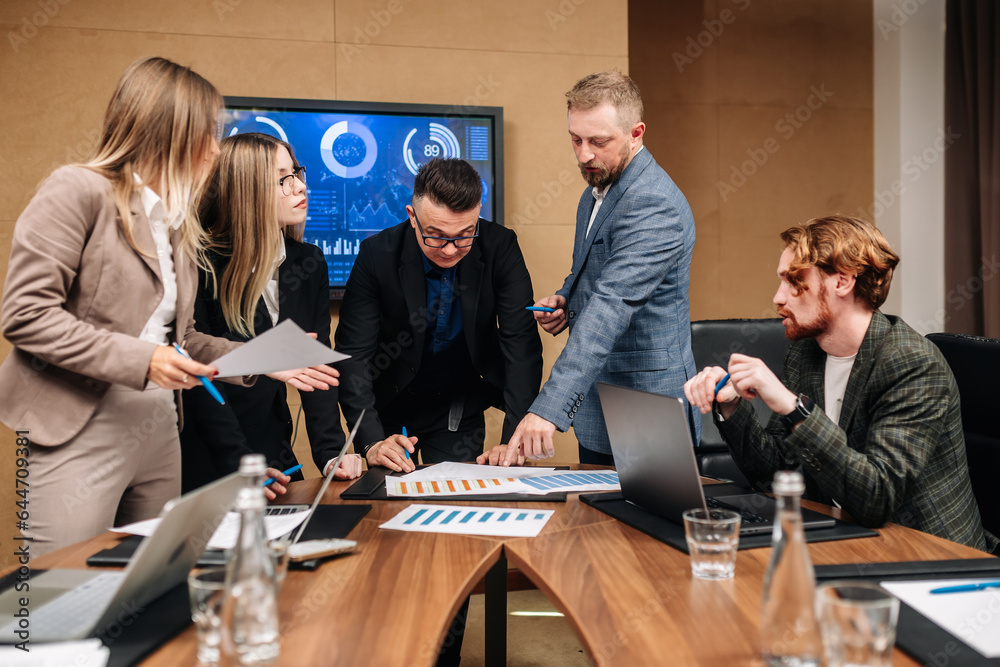 Successful entrepreneur specializing in charting during a meeting with ...