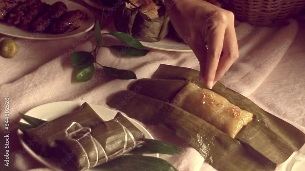 Hand adding roasted coconut pieces as toppings to suman latik or ...
