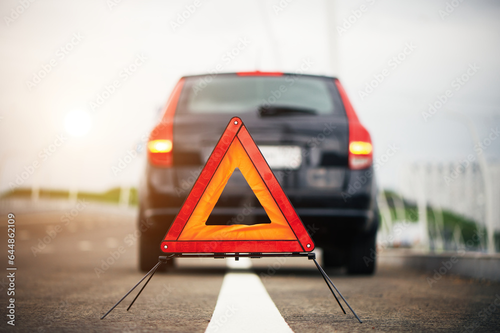 Red emergency stop sign on road. Blurred broken down car with warning ...