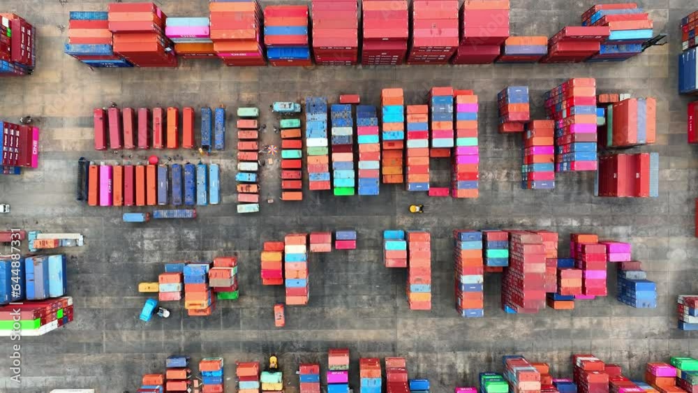 A sprawling container yard, bustling with activity, seen from above ...