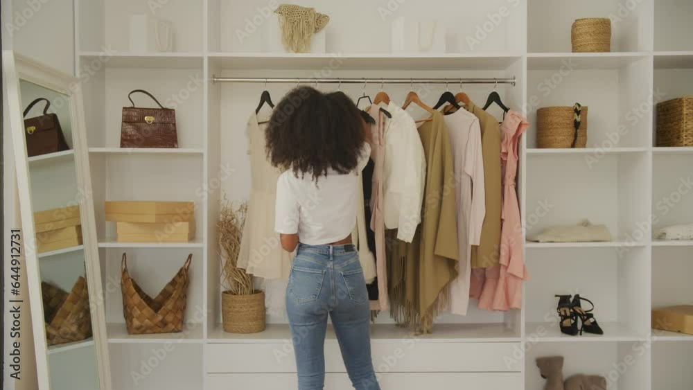 Black Woman Choosing Outfit in Wardrobe. Young adult female admiring ...