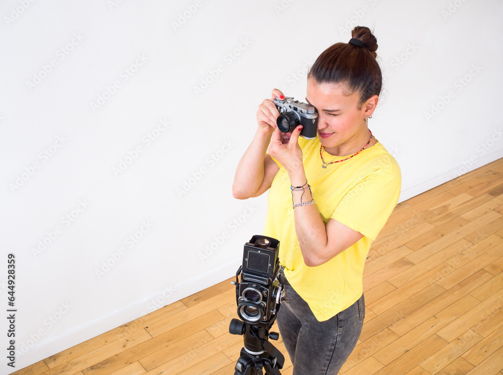 A female photographer using a vintage 35mm film rangefinder camera ...