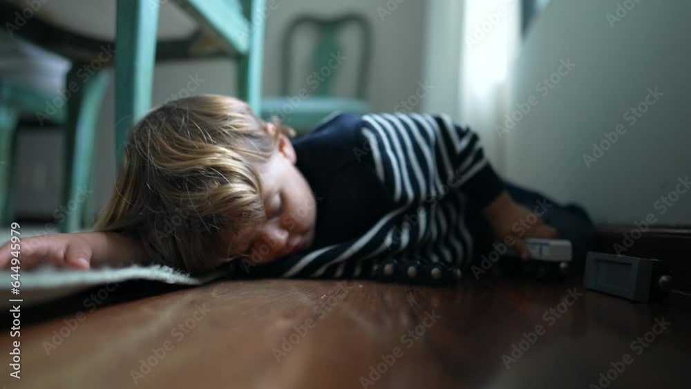 Child playing by himself on floor at home, one little boy engaged with ...