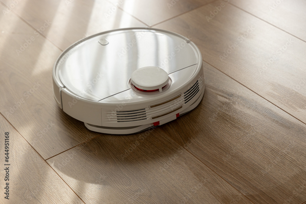 Vacuum Robot cleaning at home. Robot vacuum cleaner in the modern home ...