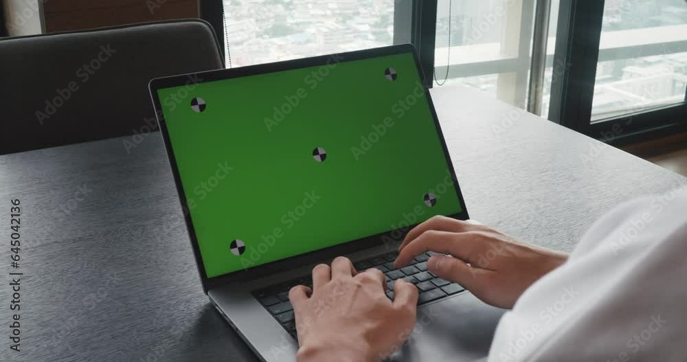 Over the shoulder shot man using laptop computer with green screen ...