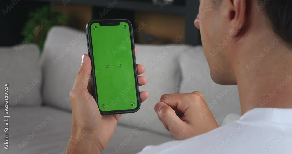 Over the shoulder shot male hand holding mobile phone in vertical ...